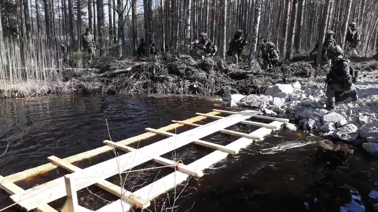 Finnish Army Combat Engineers support the Infantry's assault by building an ad hoc bridge ...