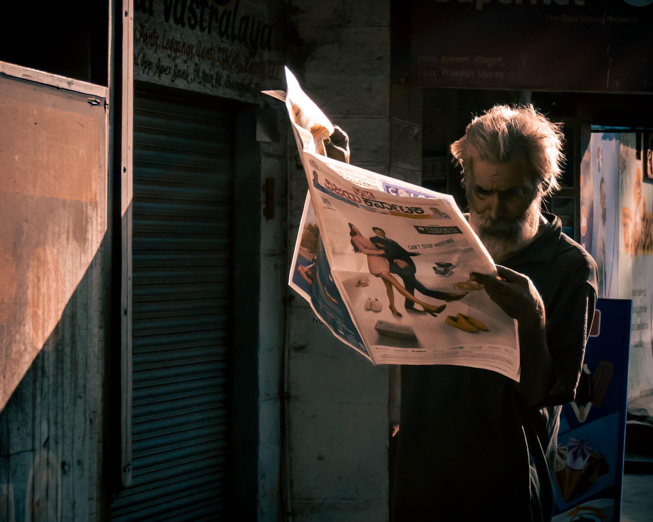 Man reading a newspaper in India. | Scrolller