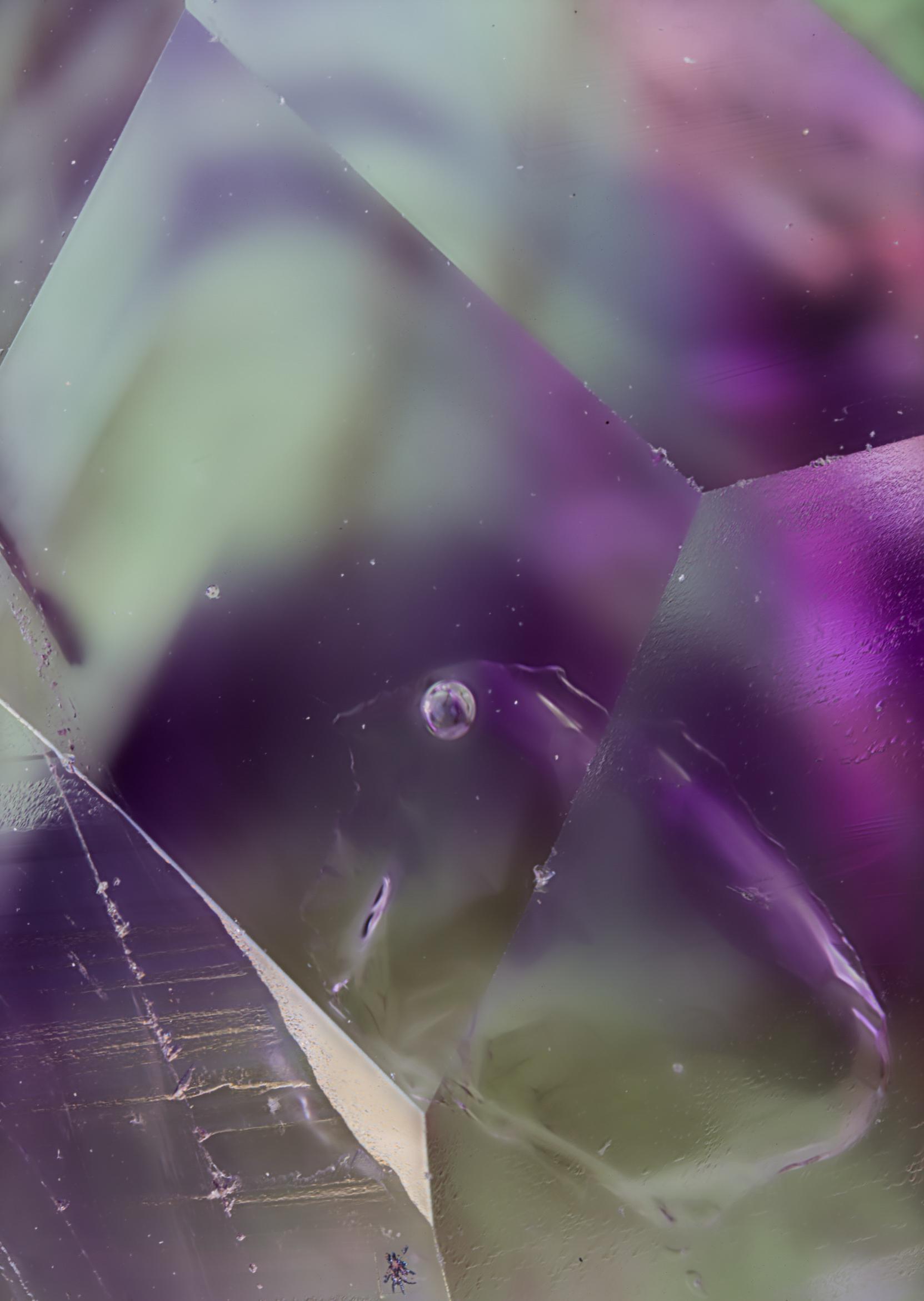 A little bubble of air in a water pocket inside an amethyst crystal. | Scrolller