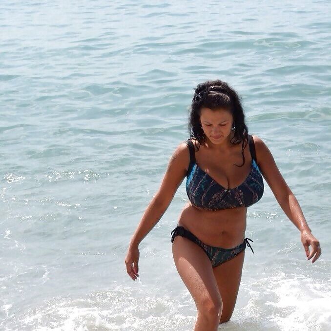 Busty lady with a nice muffin top wading through the waves | Scrolller