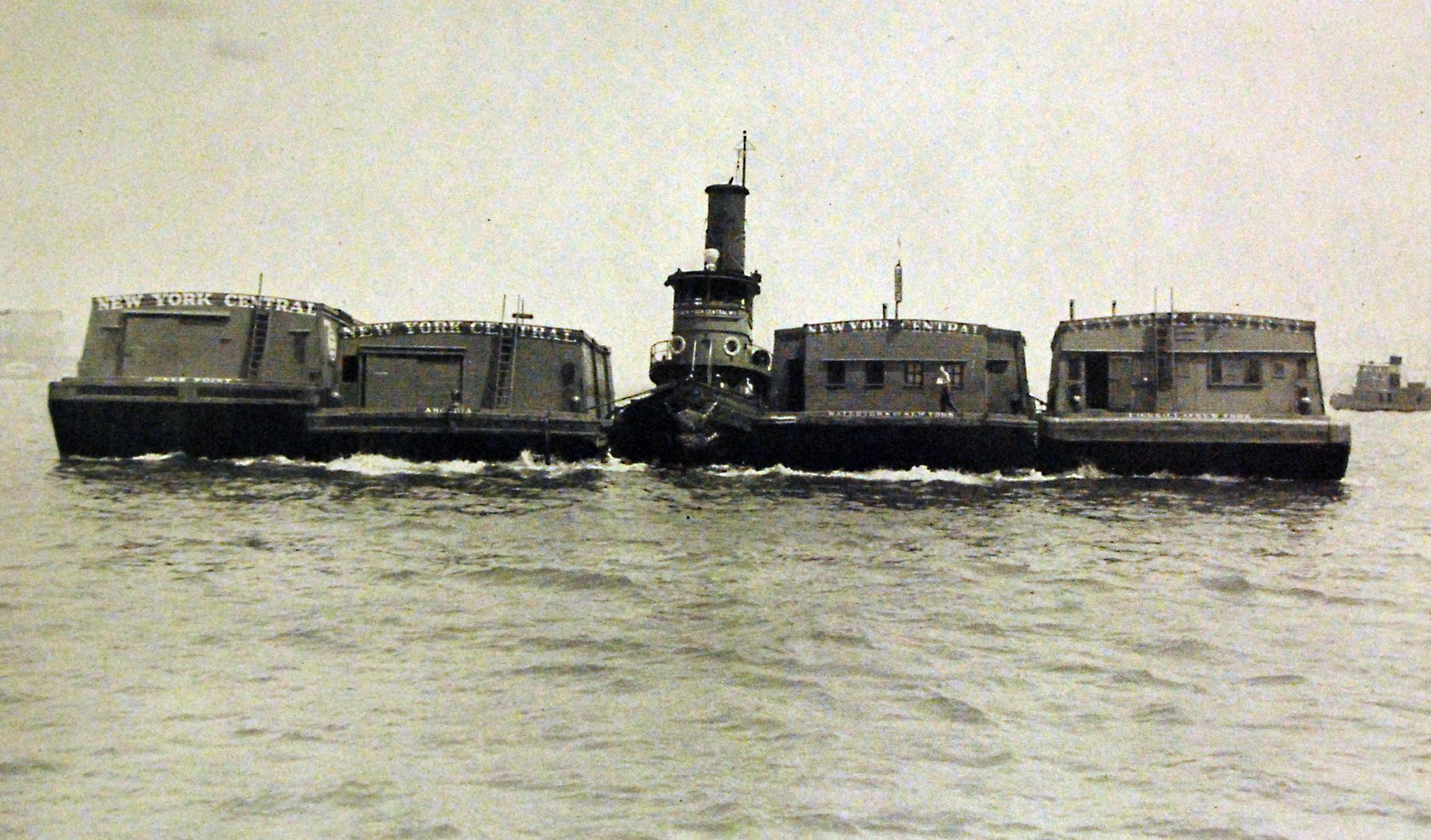 Four covered barges being towed by one little tug, 1946 | Scrolller