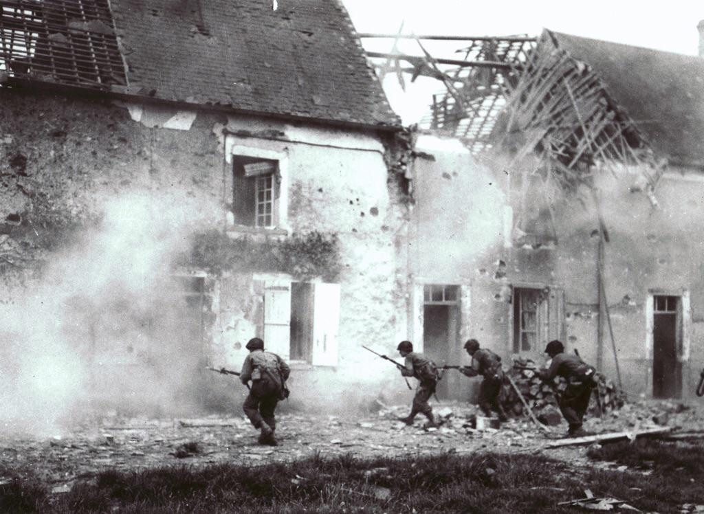 GIs rush a burning house in Sainteny, Normandy, July 11, 1944. | Scrolller