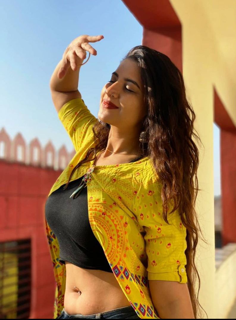 Jolly Bhatia navel in black top and yellow jacket and black jeans | Scrolller