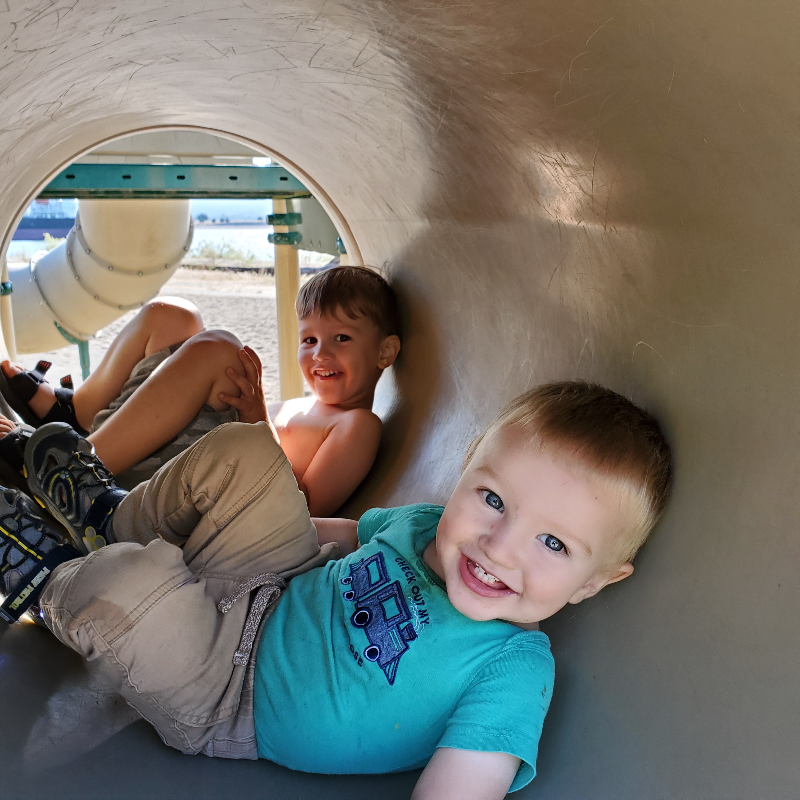 My boys posing for the camera inside a playground tube | Scrolller