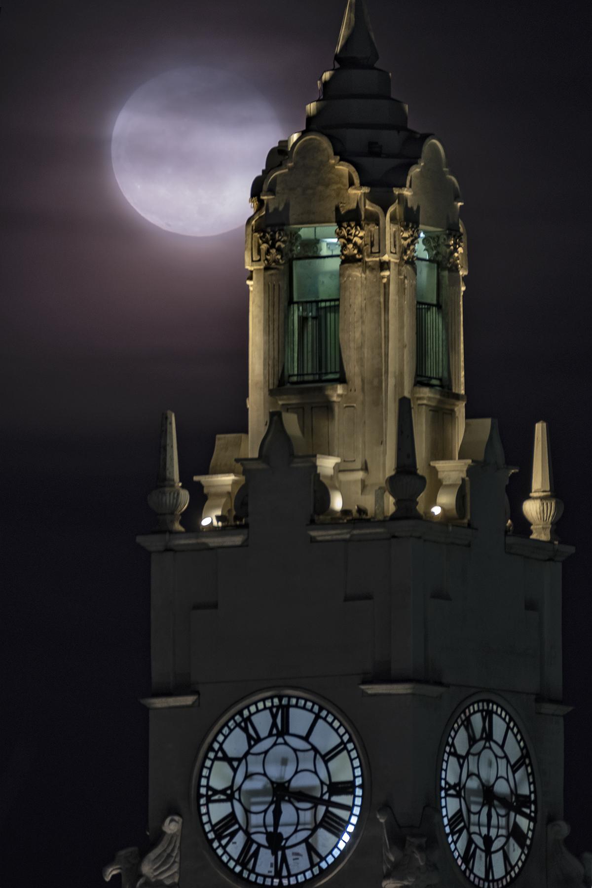 Photo of the moon behind the clocktower | Scrolller