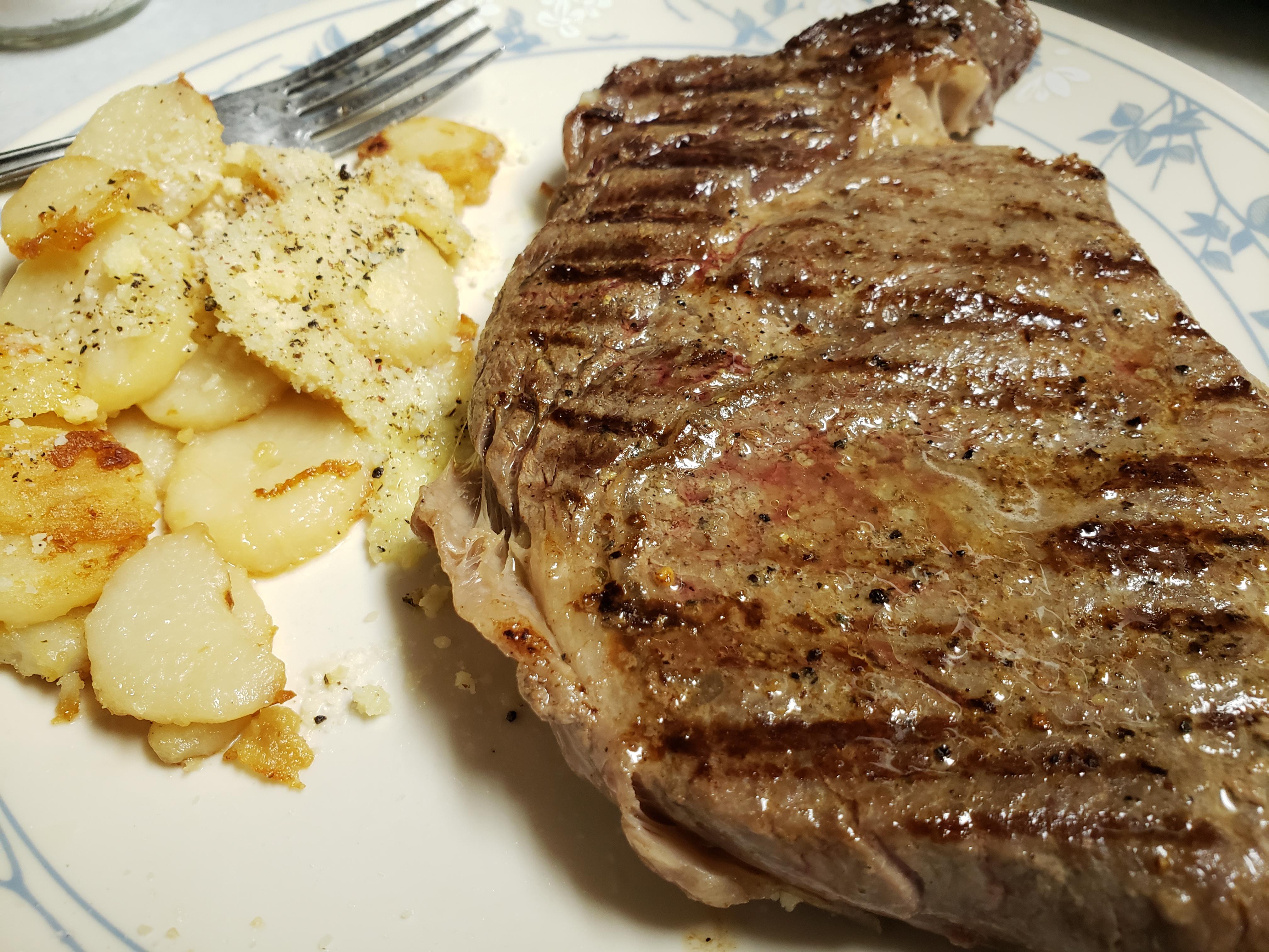 Sous vide ribeye with some fried sliced potatoes. | Scrolller