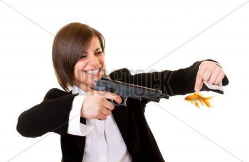 Woman threatening goldfish with pistol while smiling | Scrolller