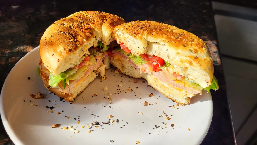 Bagel ham and colby jack cheese sandwich, lettuce, tomato, green onion, mayo, mustard. | Scrolller
