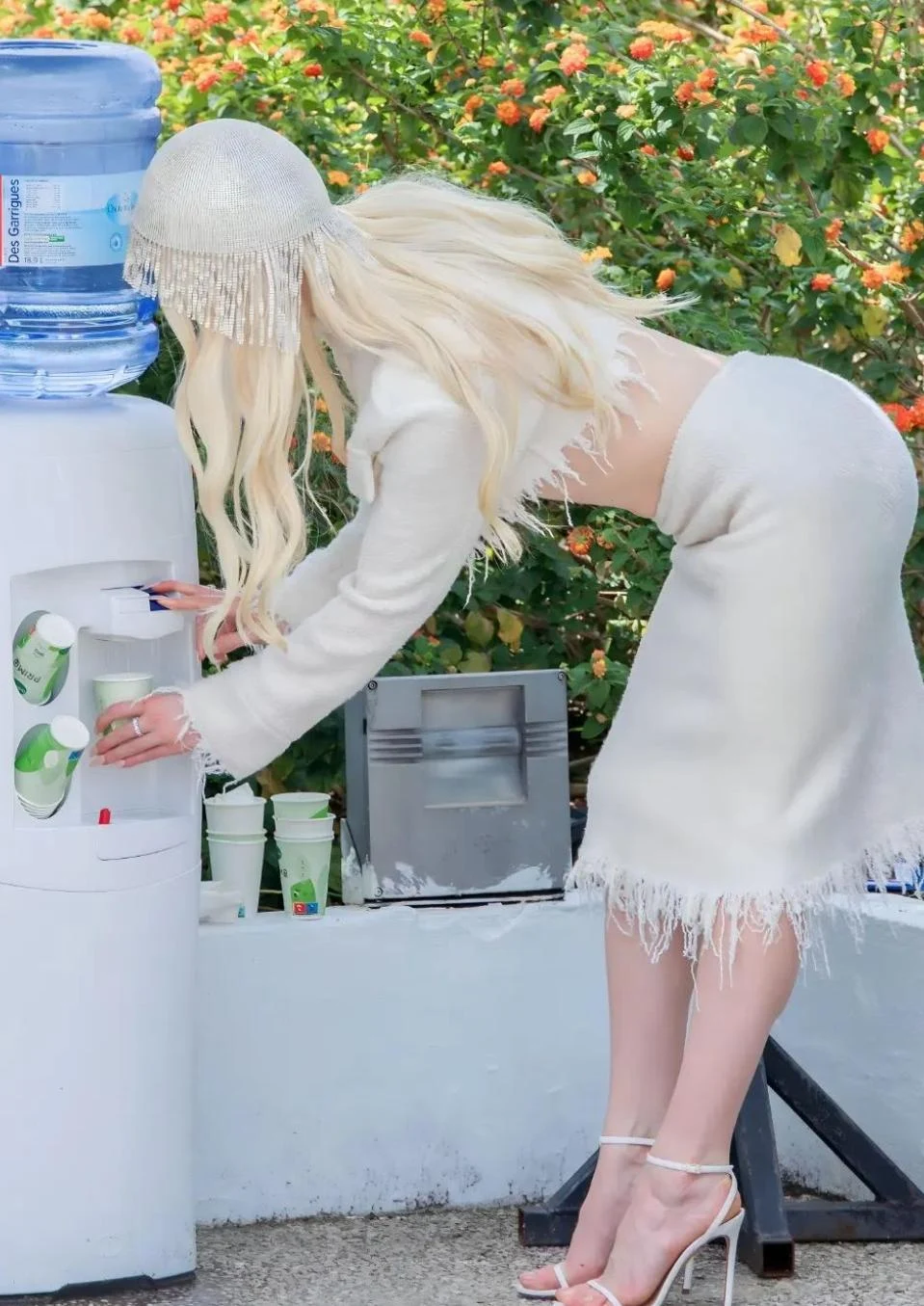 I've never seen someone dressed this glamorous use a water cooler. | Scrolller