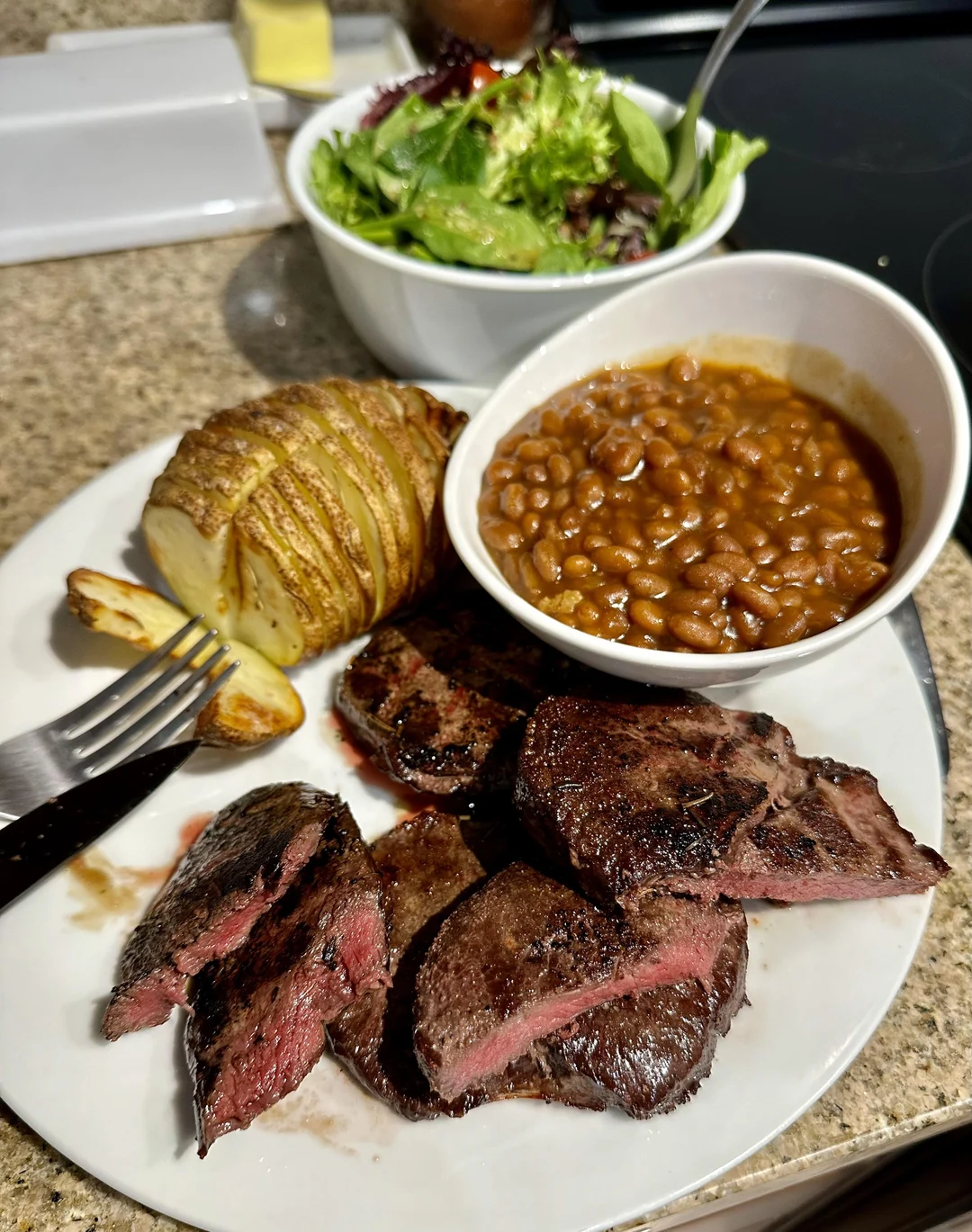 Venison chops with a hasselback potato, baked beans and salad | Scrolller