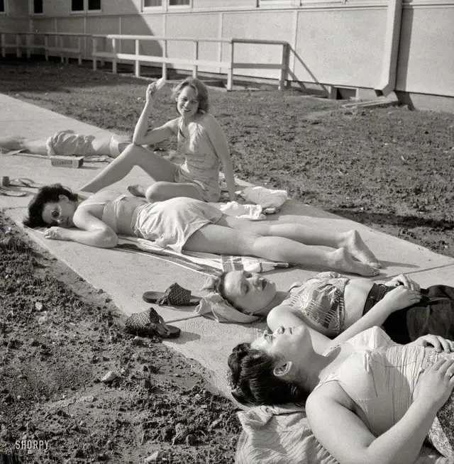 War workers sunbathing on the sidewalk in the back of their residence hall, Arlington VA, June ...