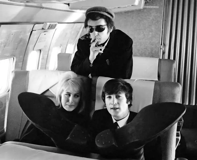 Phil Spector (standing) with John Lennon and his first wife, Cynthia, on board a Pan Am airliner ...