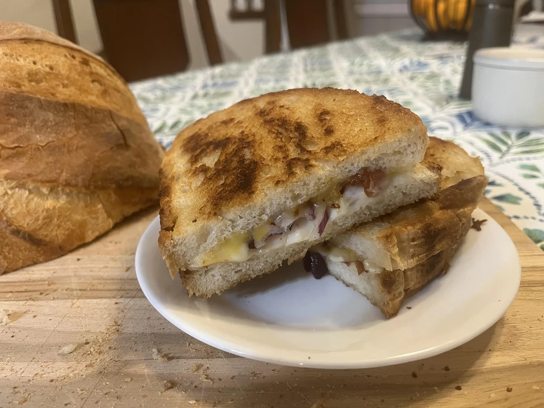 Grilled provolone and cheddar jack with red onion and bacon on homemade bread. | Scrolller