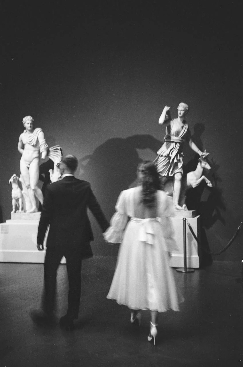 An elegant couple's evening stroll through the sculpture gallery – Captured in 1983 | Scrolller