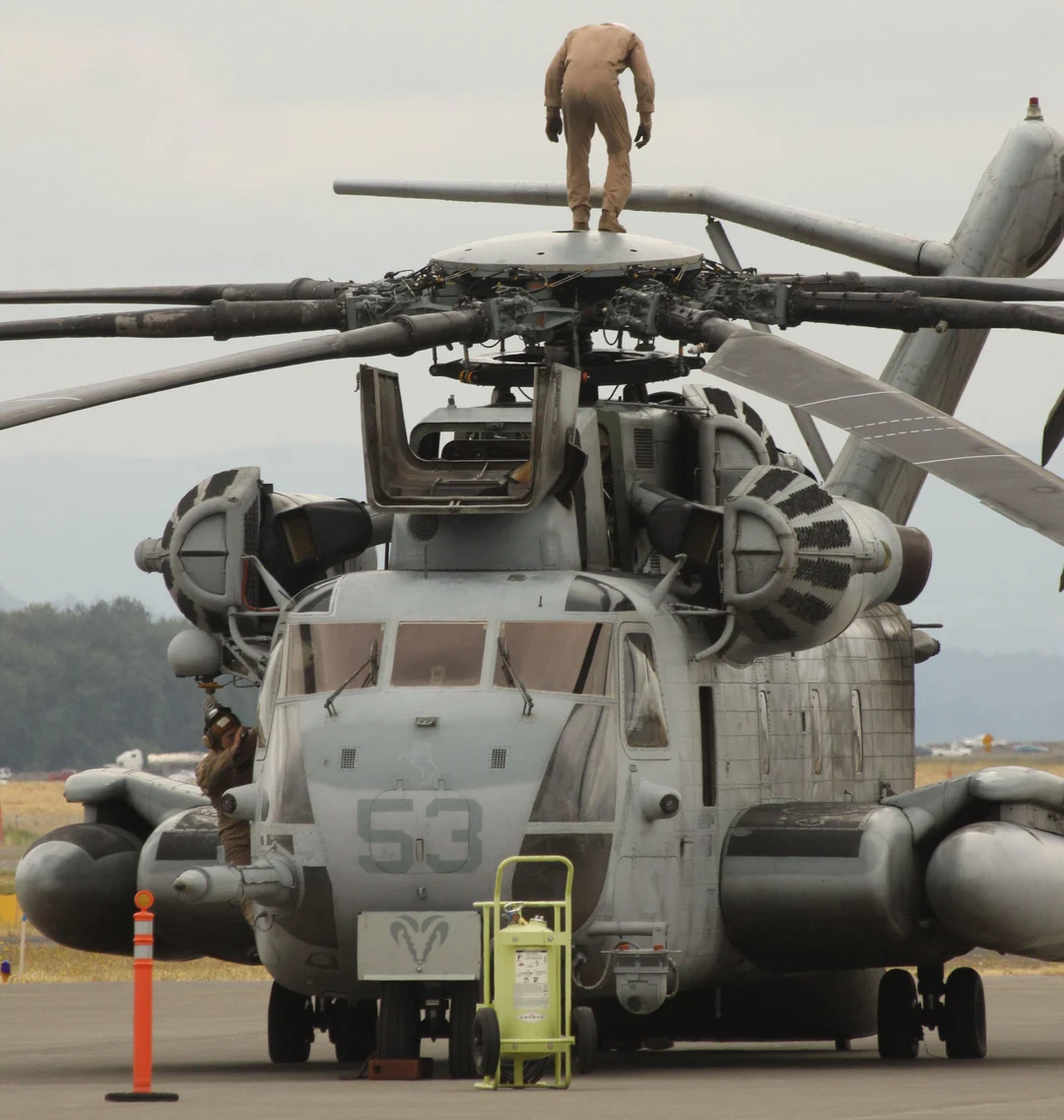 Engineer standing on the rotor of a CH-53E Super Stallion helicopter. | Scrolller