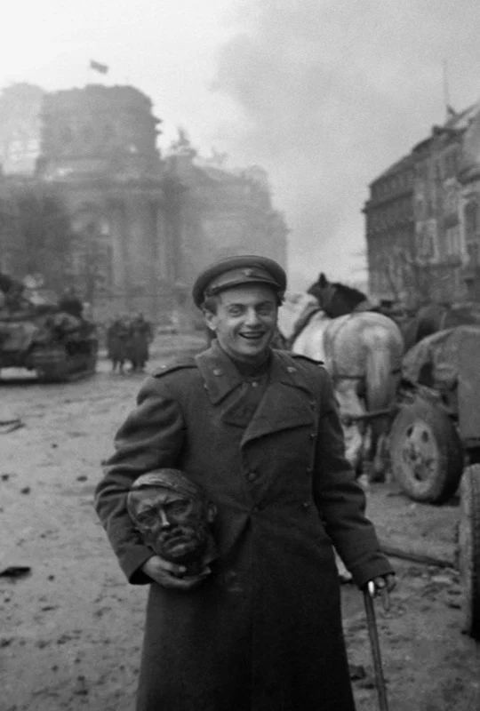 A Soviet soldier with the head of a statue of Hitler, Berlin, 1945 | Scrolller