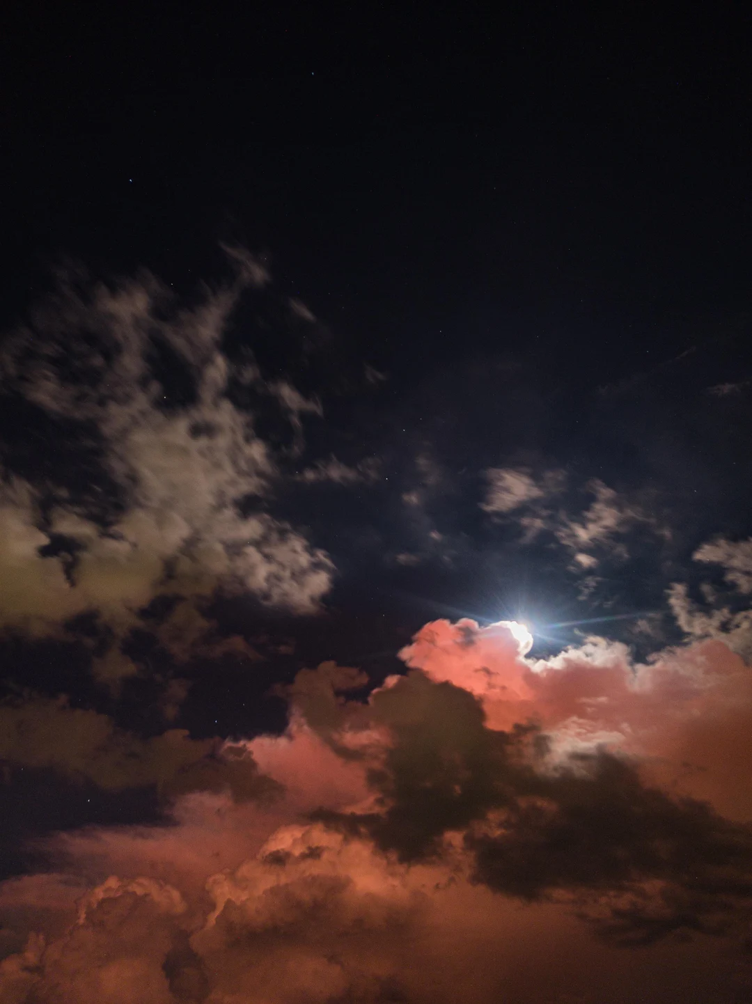 the moon rising behind the clouds | Scrolller