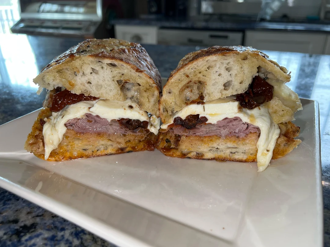 Prosciutto, sundried pesto, mozz, sundried tomato, olive oil on pesto bread | Scrolller