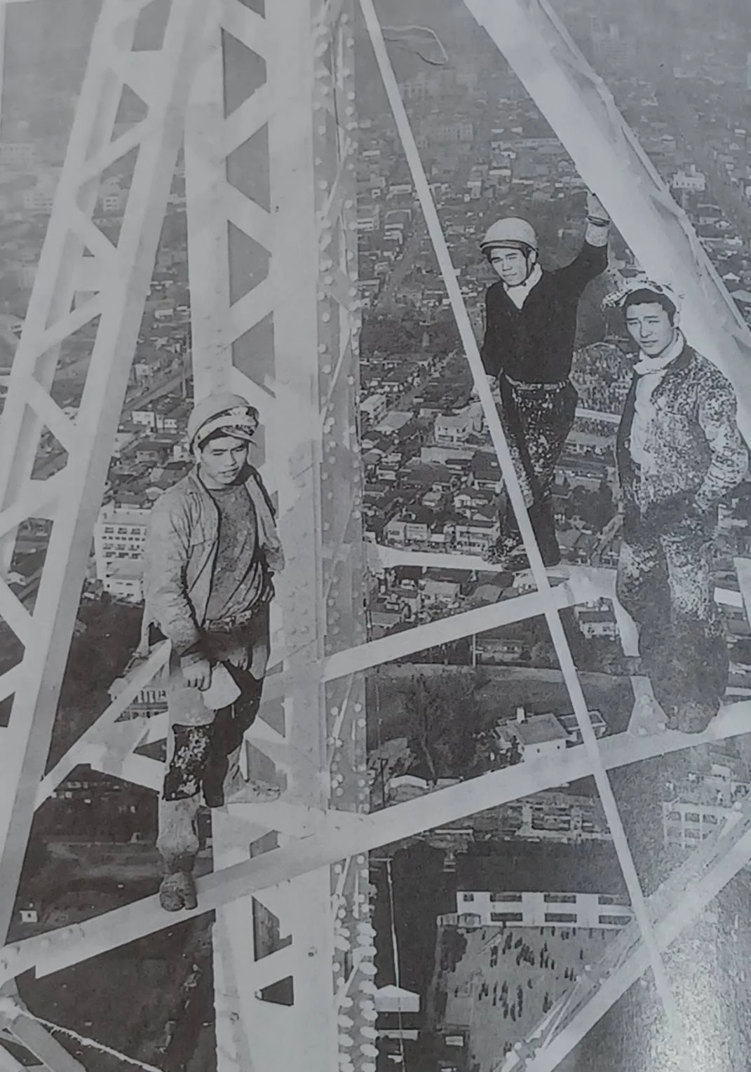 Painters of Tokyo Tower(333m high) standing on its steel frame near the top of the tower without ...