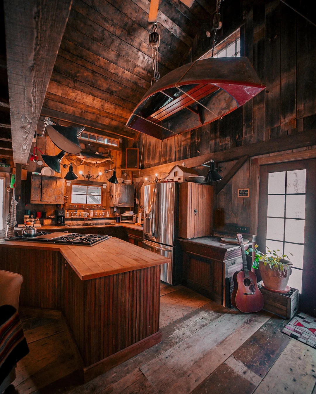 Rustic Cabin Kitchen with a Boat Hanging from the Ceiling | Scrolller