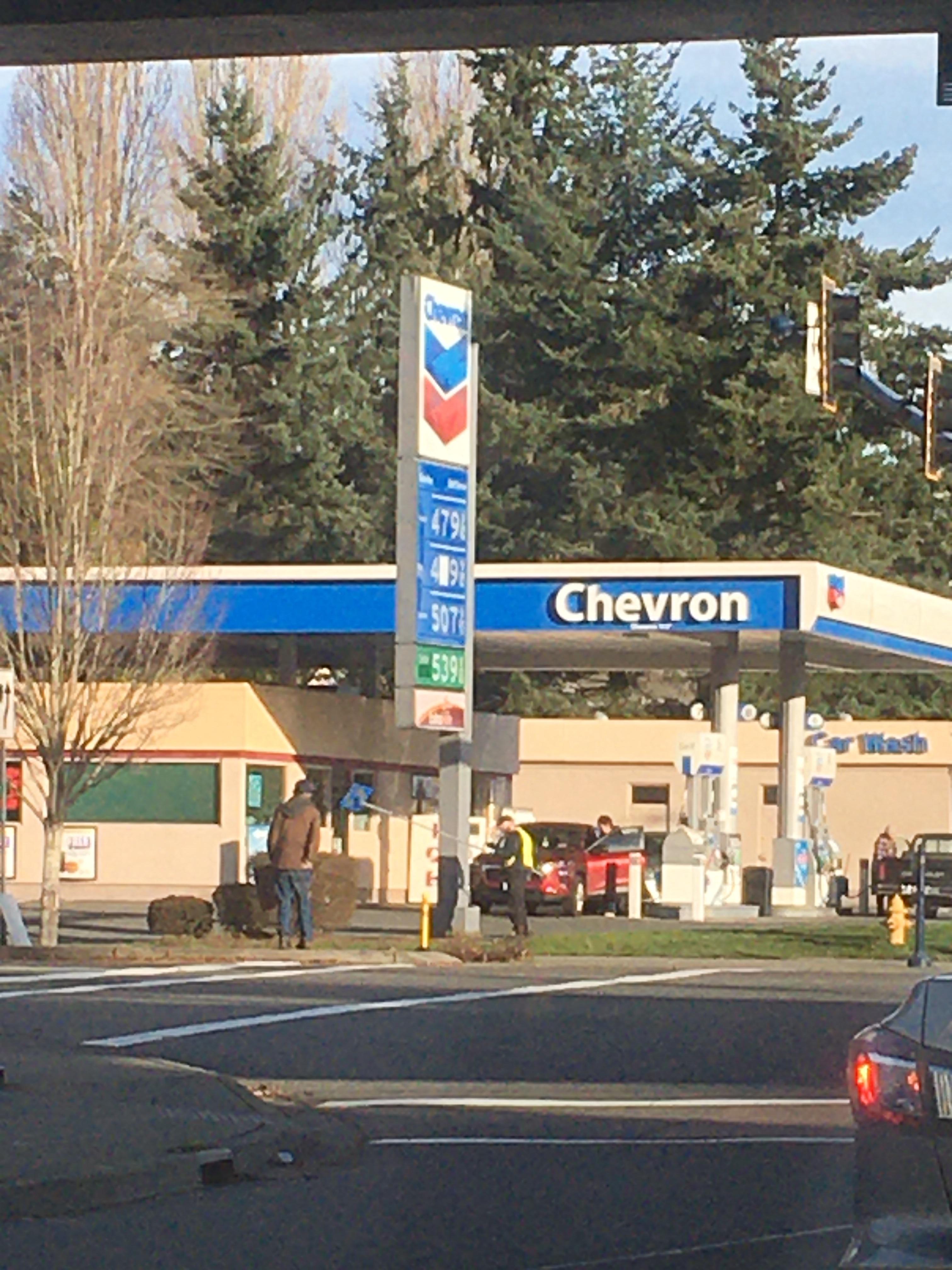 People using a suction cup on a long pole to change gas station prices ...