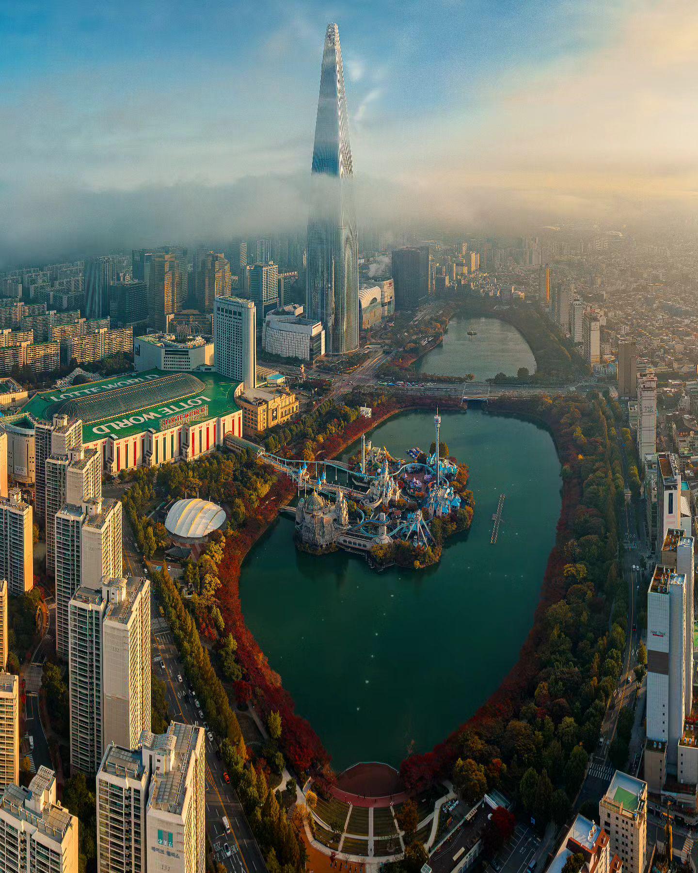 Lotte World Tower partially obscured by a sea of clouds above Seokchon Lake, Songpa District ...