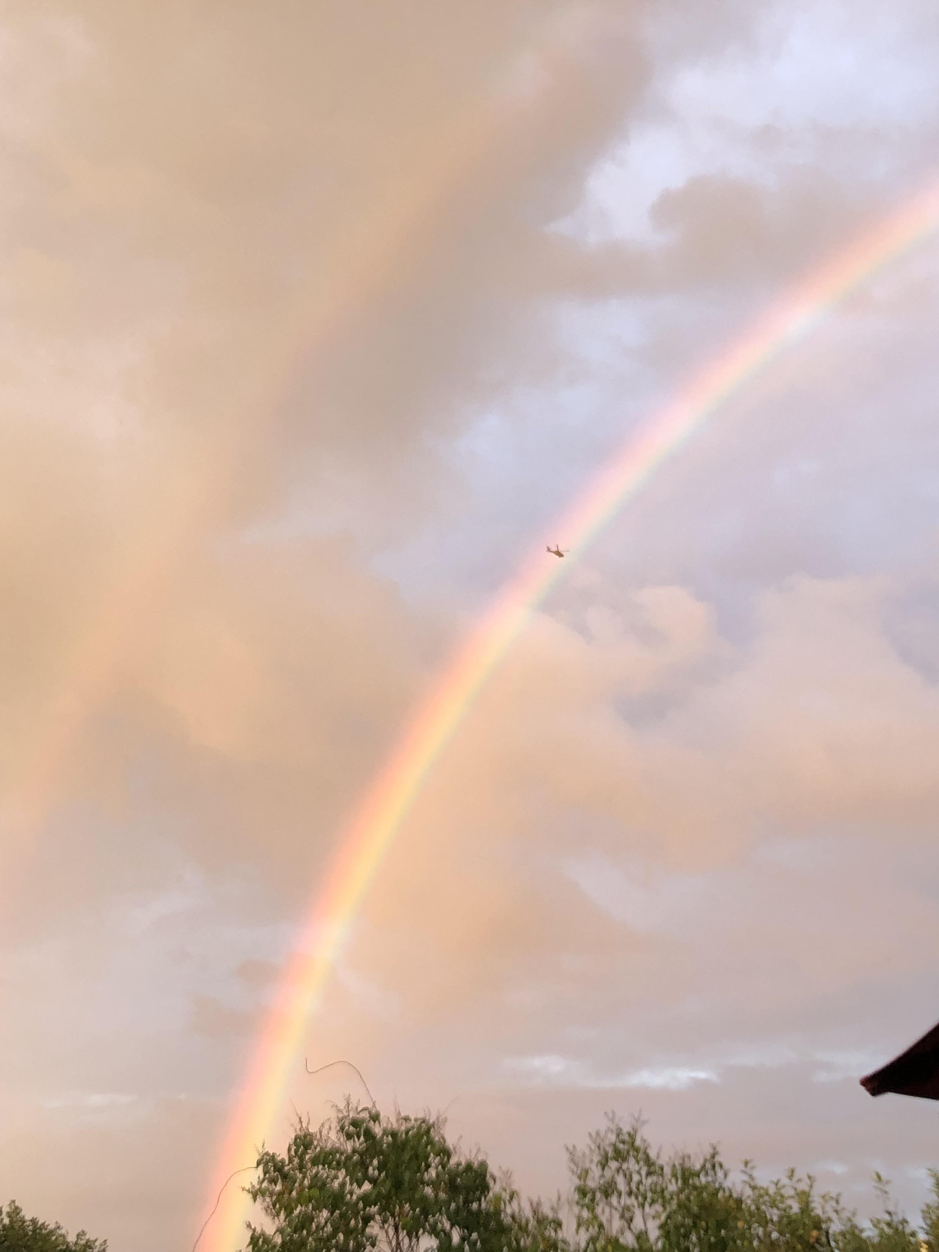 Helicopter flying through a double rainbow | Scrolller