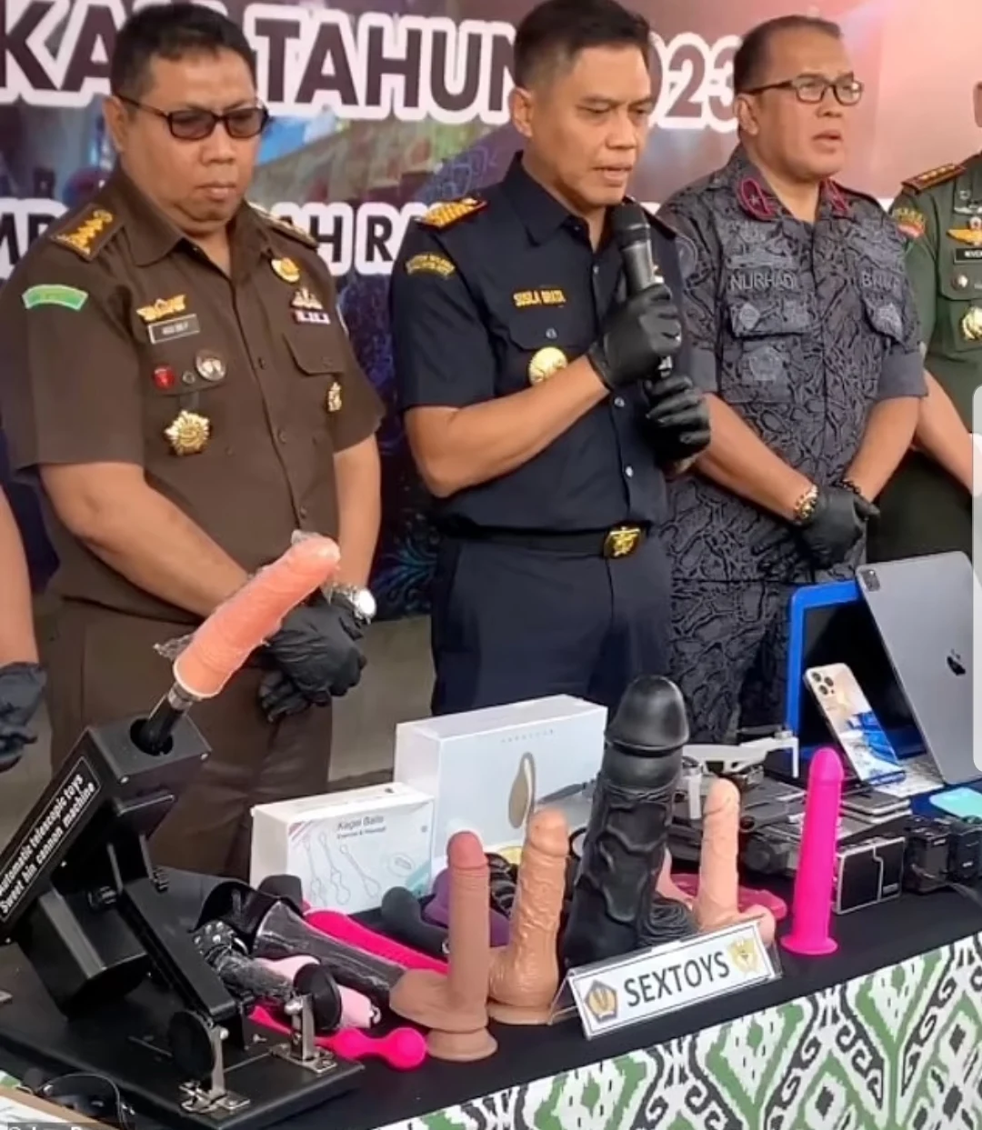 Customs Officials Stand Near Confiscated Items at Bali Airport Press Conference | Scrolller