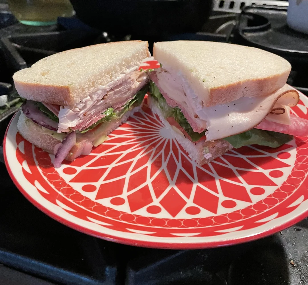 Smoked turkey & hard salami with avocado, red onion, lettuce, tomato, mayo and Swiss cheese on ...