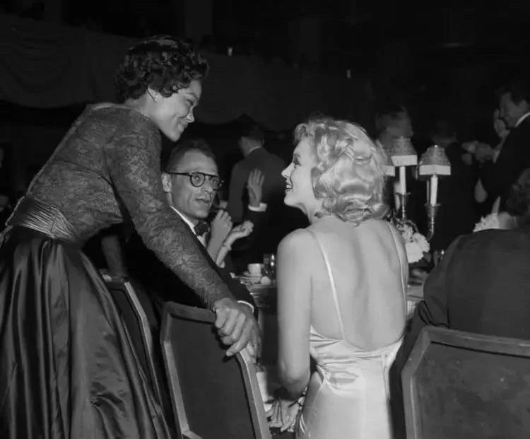 Eartha Kitt talking with Marilyn Monroe at a charity dinner event at the Waldorf-Astoria in ...