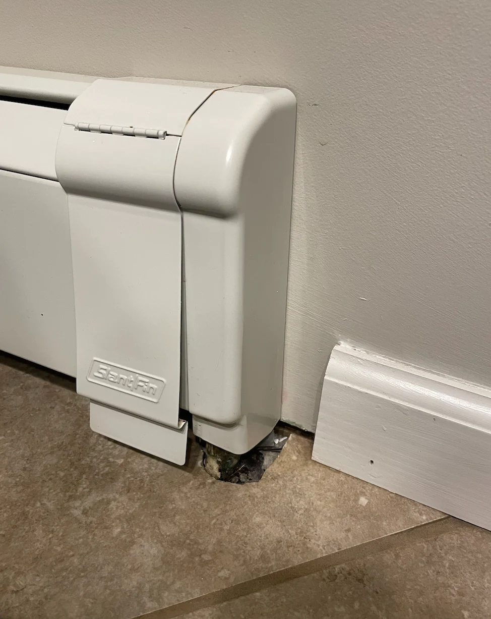 Crappy tile cut around baseboard heater from previous owner's DIY. Any way to make this look ...