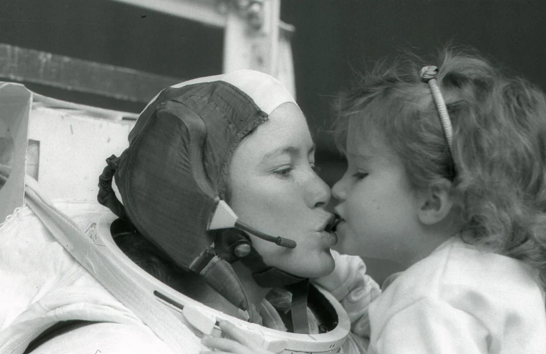 Astronaut Anna Fisher kisses her daughter Kristin after training in Houston for a spacewalk in ...