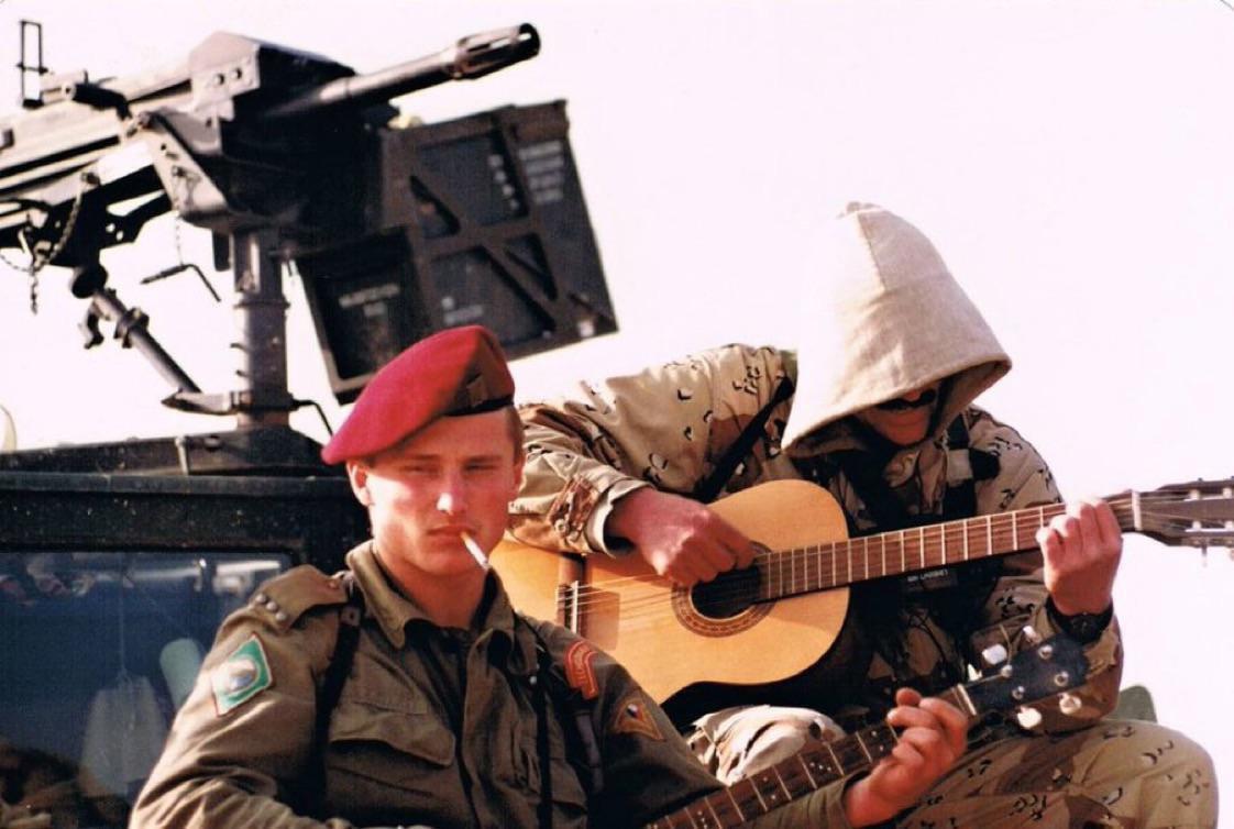 A Saudi soldier playing guitars during a break with a Czechoslovak Paratrooper in Kuwait City ...