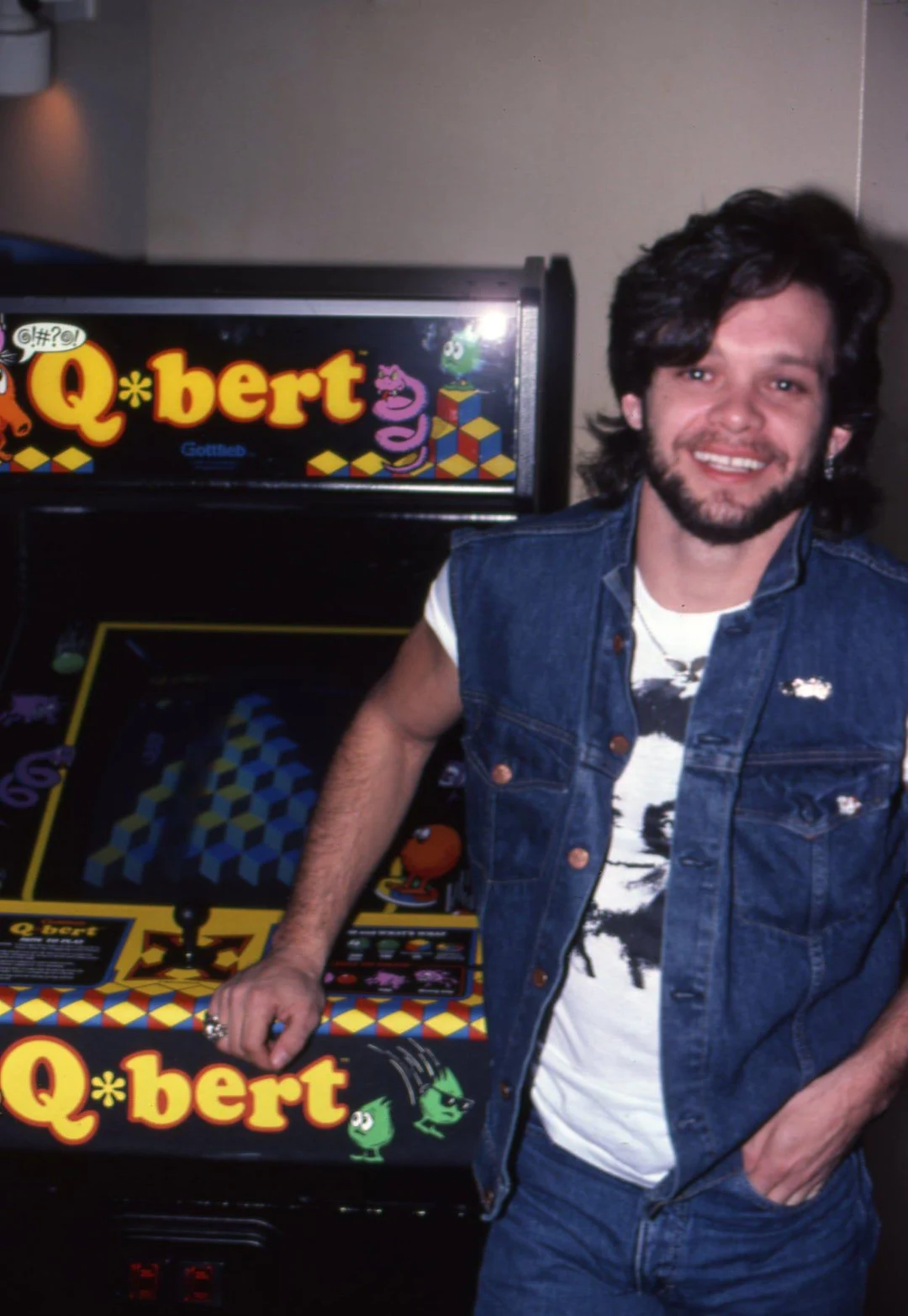 John Mellencamp posing with Q*Bert arcade game, early 1980s | Scrolller