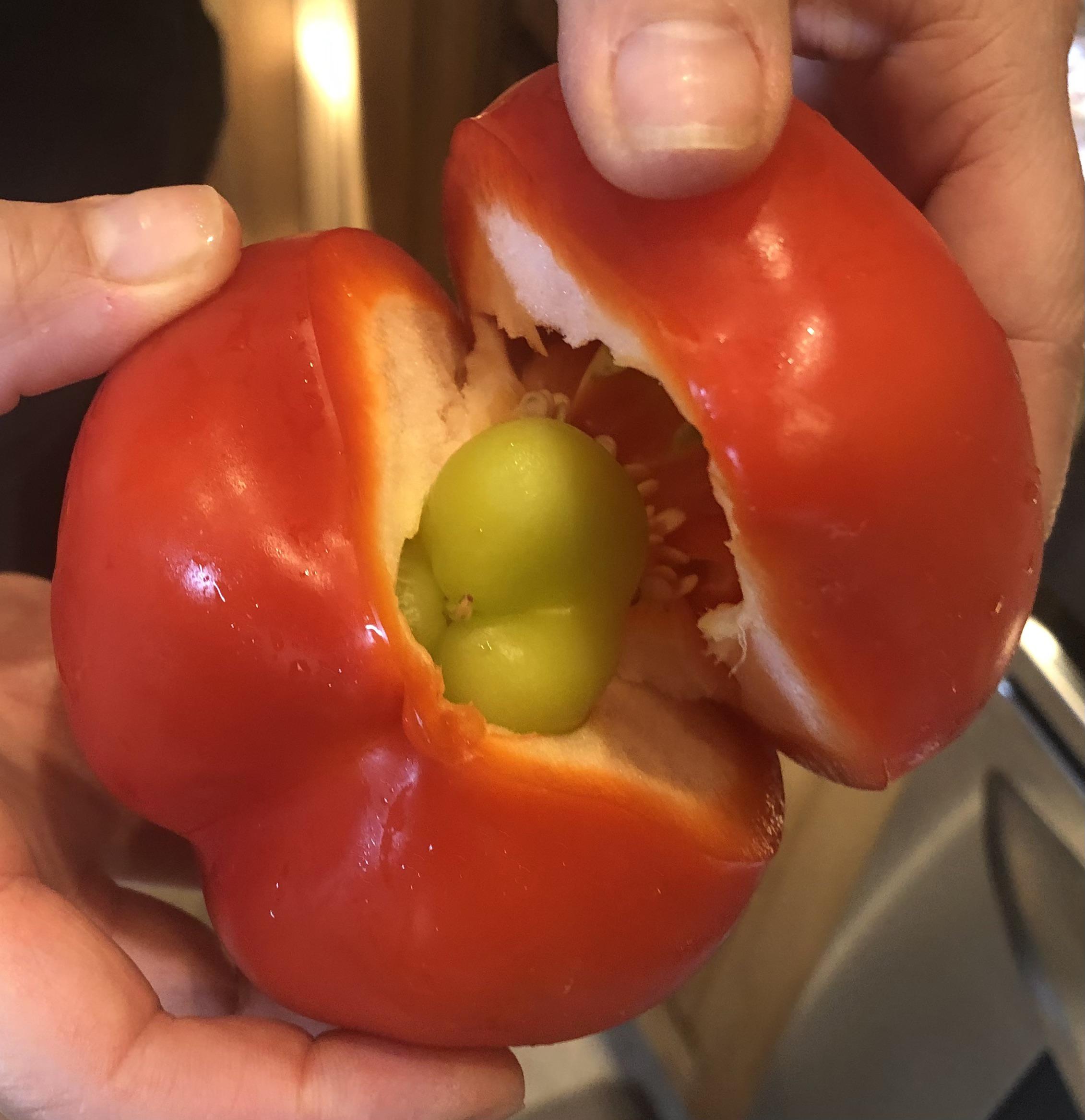 A green pepper growing inside a red pepper | Scrolller