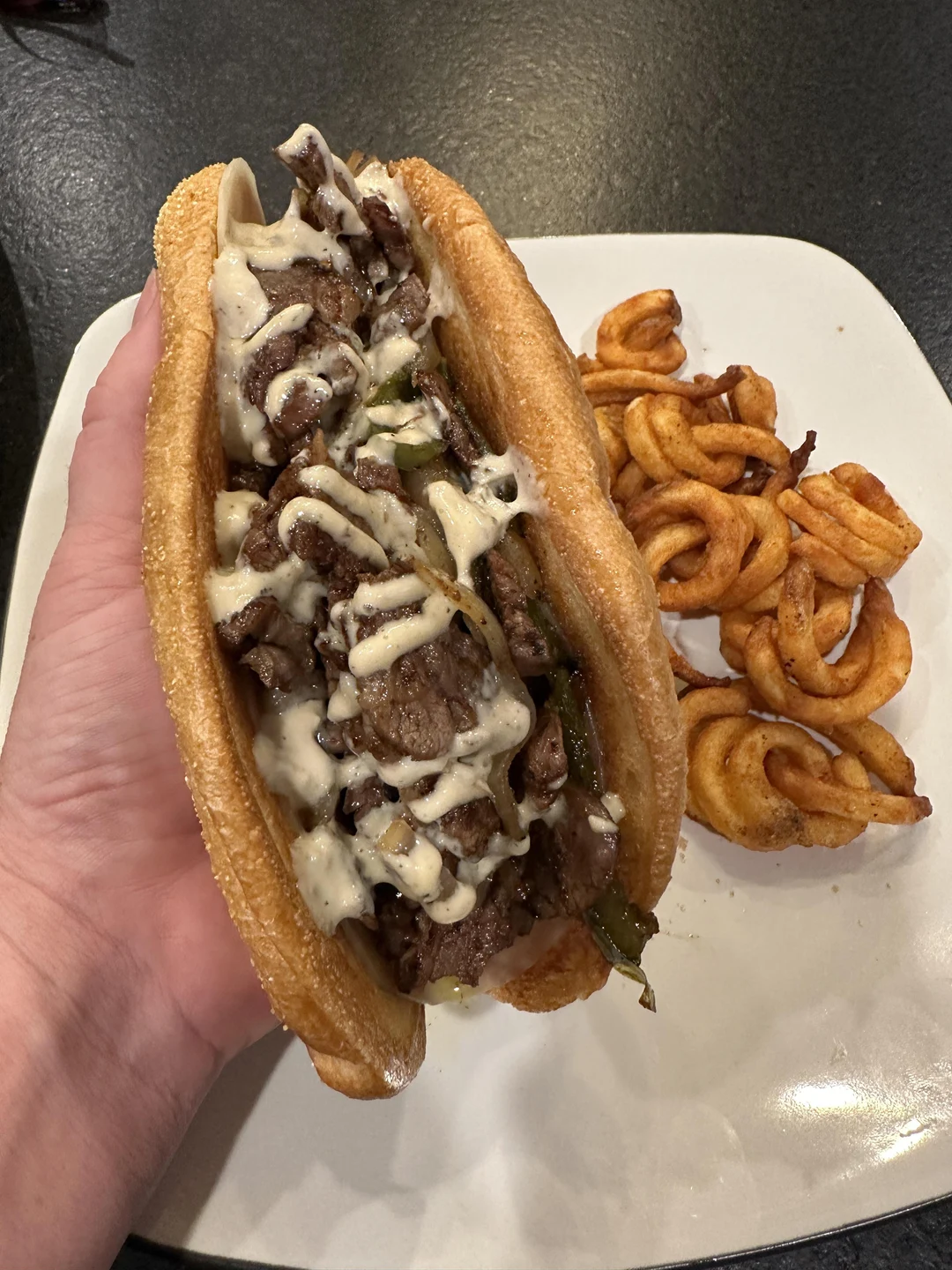 Steak sandwich with a bunch of garlic aioli, provolone, peppers and onions | Scrolller