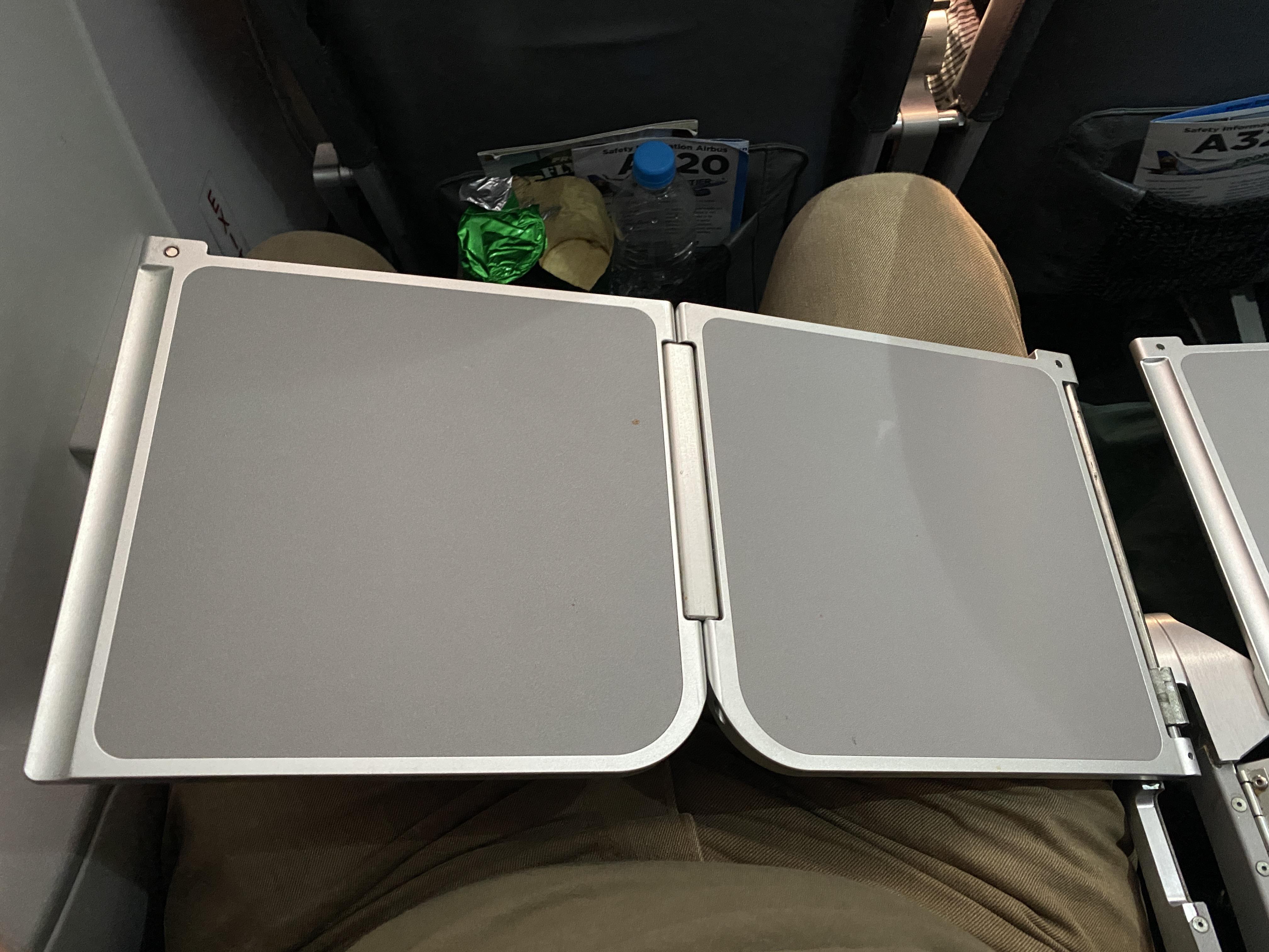 Exit row, check. Cheap airline seat tray that is too low, check. | Scrolller
