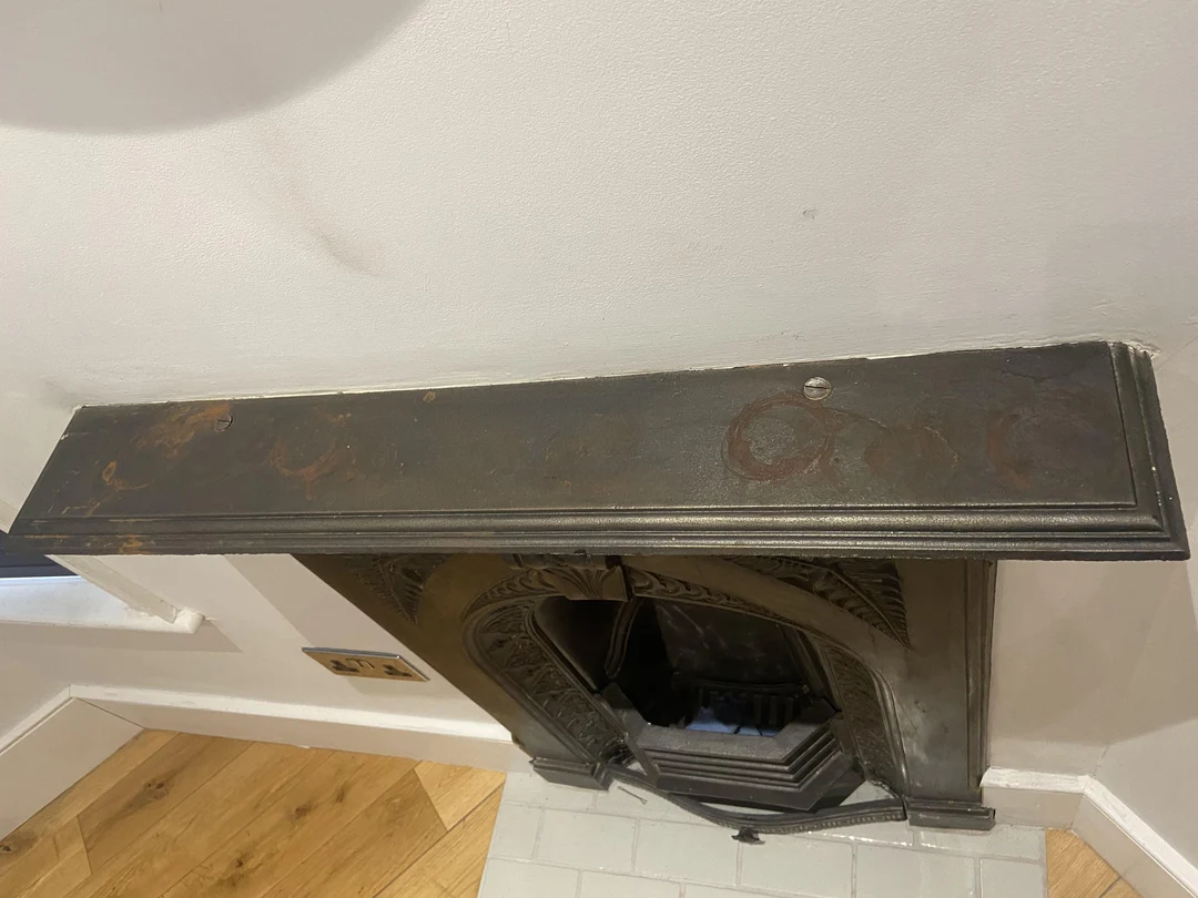 Water stained cast iron fireplace mantle | Scrolller