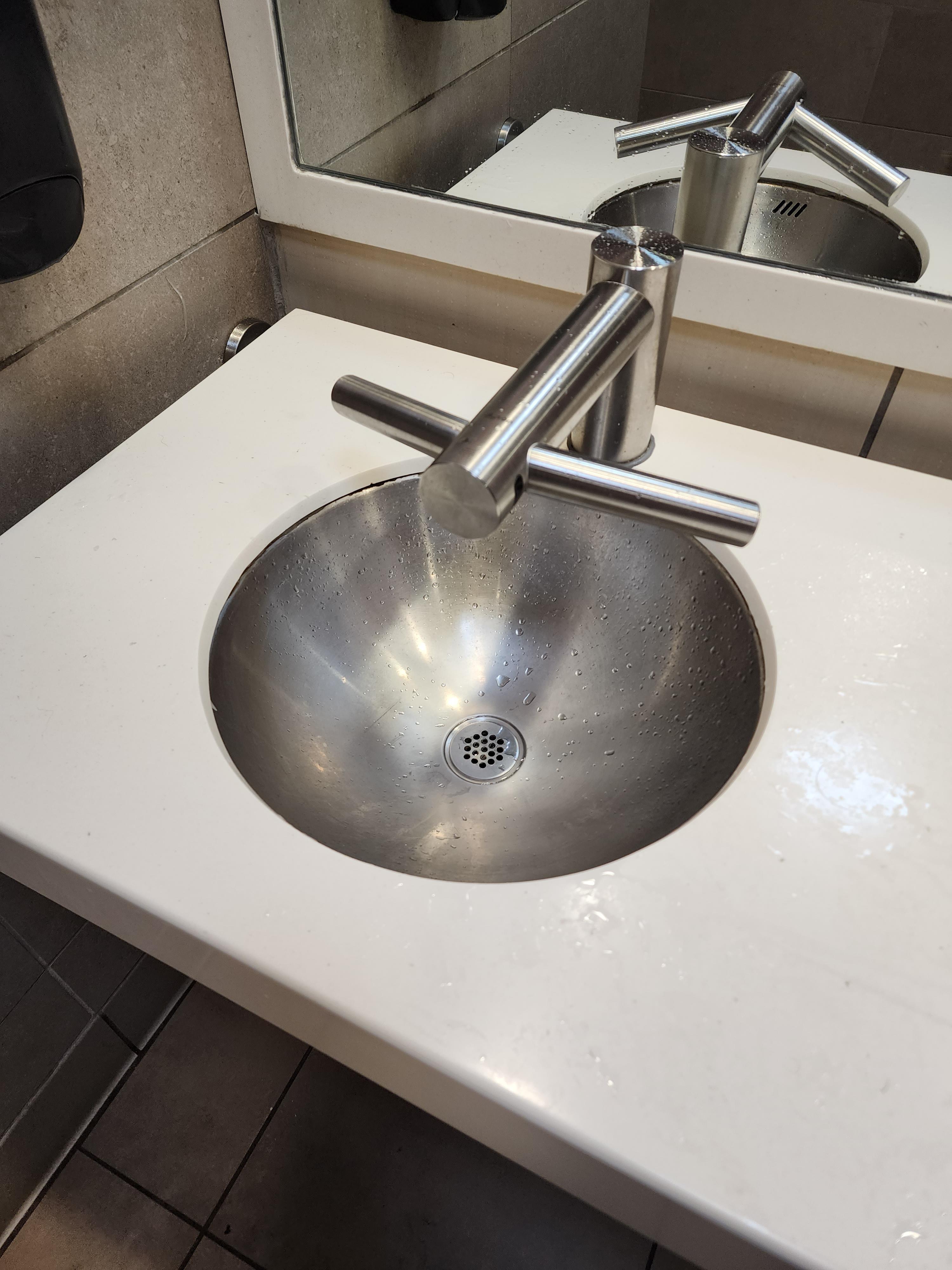 This restaurant bathroom has the hand dryer built into the sink. | Scrolller