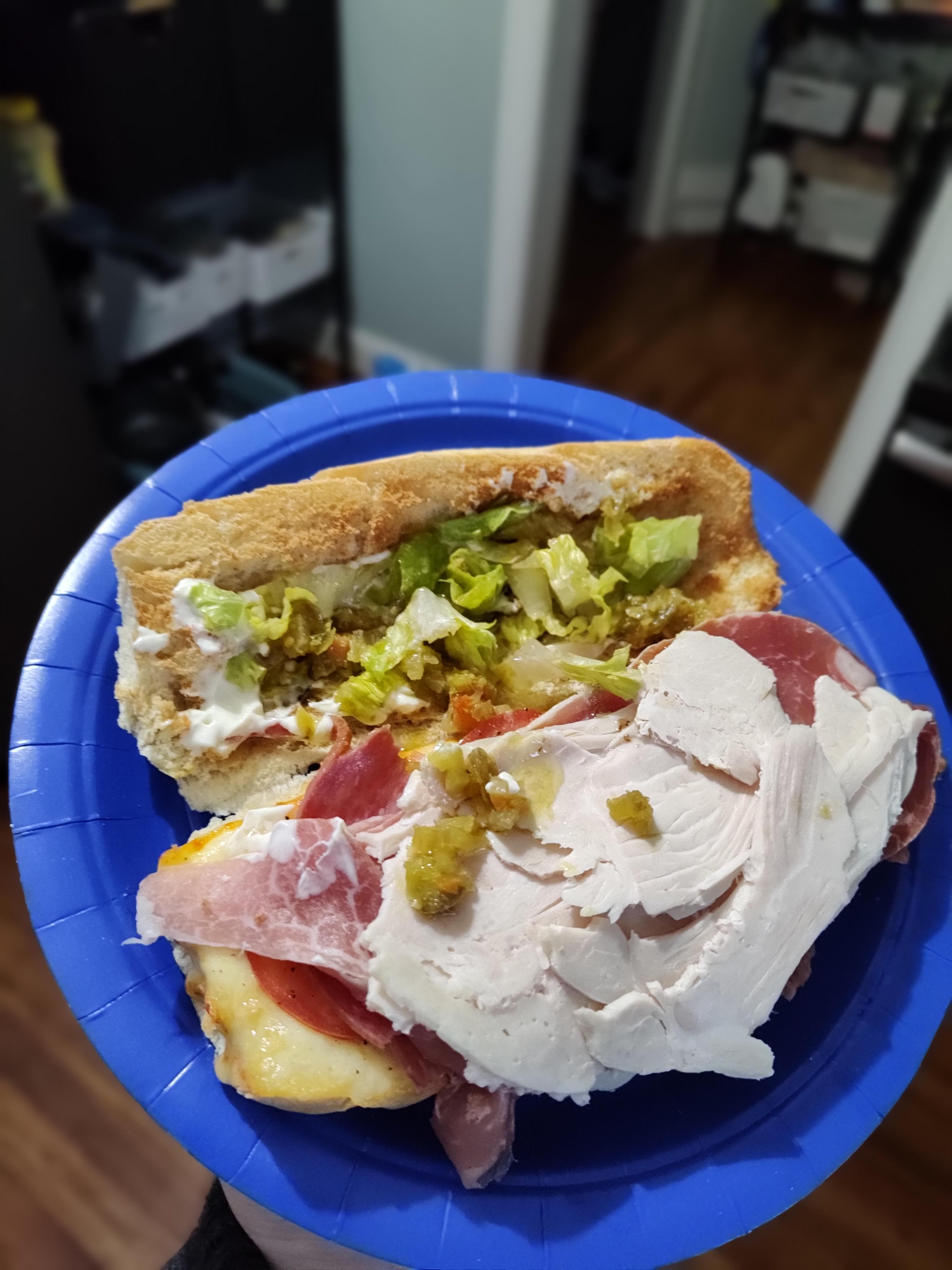 French bread with dukes, hot relish, muenster, turkey, prosciutto, and salami. | Scrolller