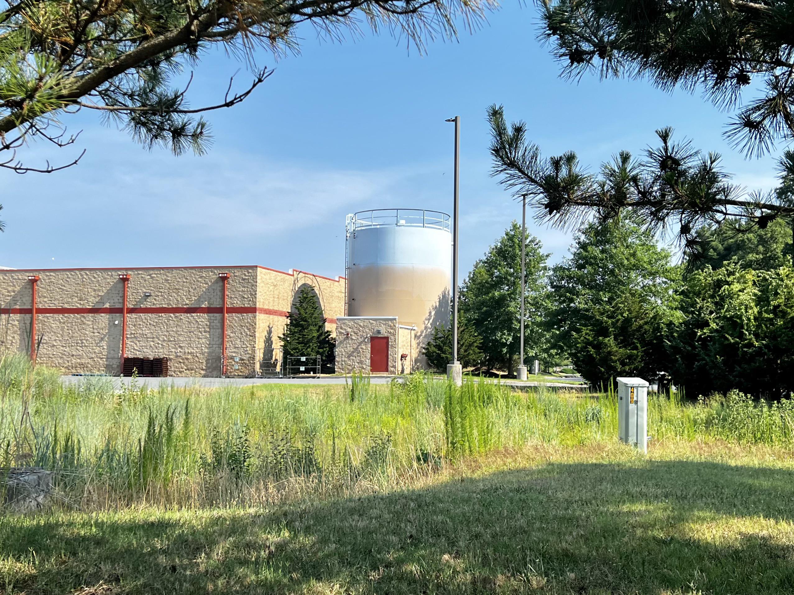 A water tower painted to blend in both with the building and the sky | Scrolller