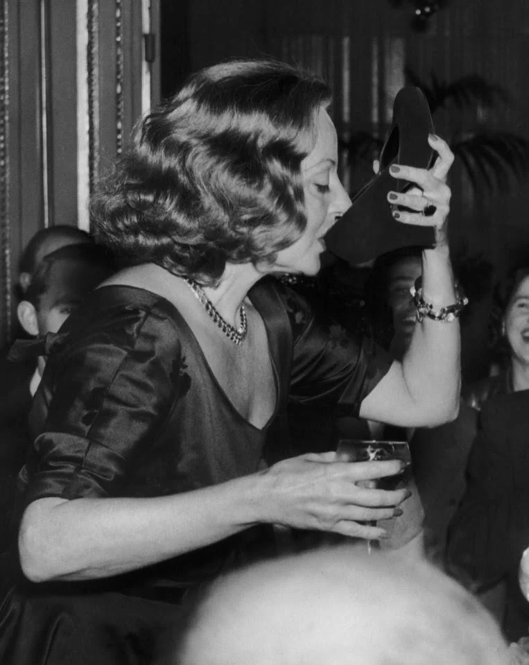 Tallulah Bankhead drinking champagne from her shoe during a press conference at the Ritz Hotel ...