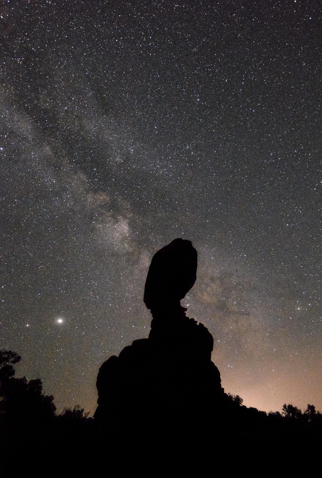 The Milky Way core flying high above Arches NP | Scrolller