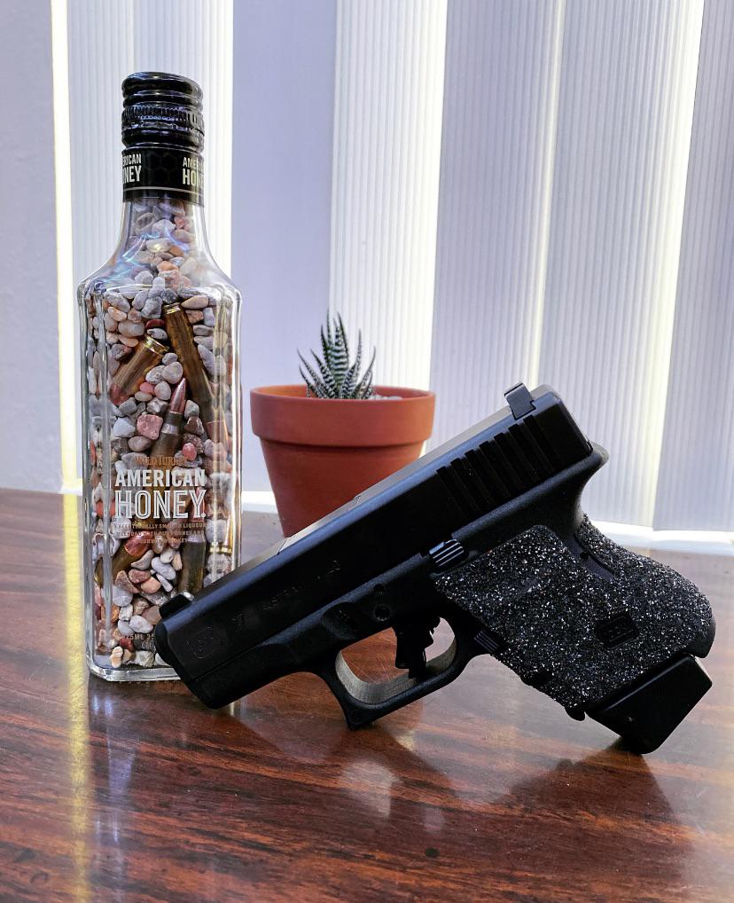 Little shelf decoration thing I made with a whiskey bottle, some ammo, and rocks for my home ...