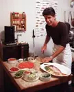 Anthony Bourdain preparing a meal in his New York City apartment, 1986 | Scrolller