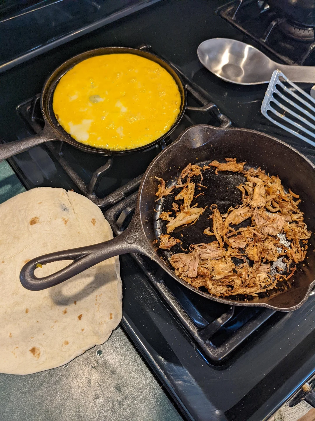 Crispy pulled pork for breakfast burritos. Cast iron homemade tortillas off screen | Scrolller
