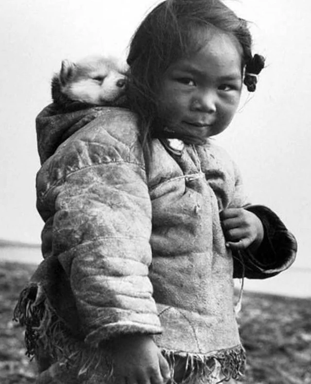 Inuit girl with her Husky puppy (1949). | Scrolller