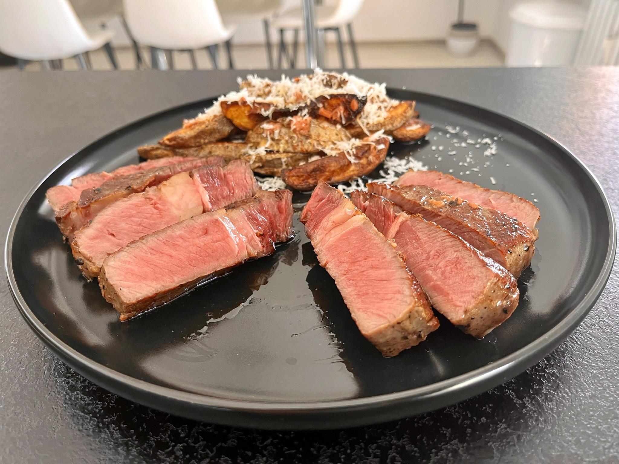 Sous vide steak seared in cast iron with potato wedges | Scrolller