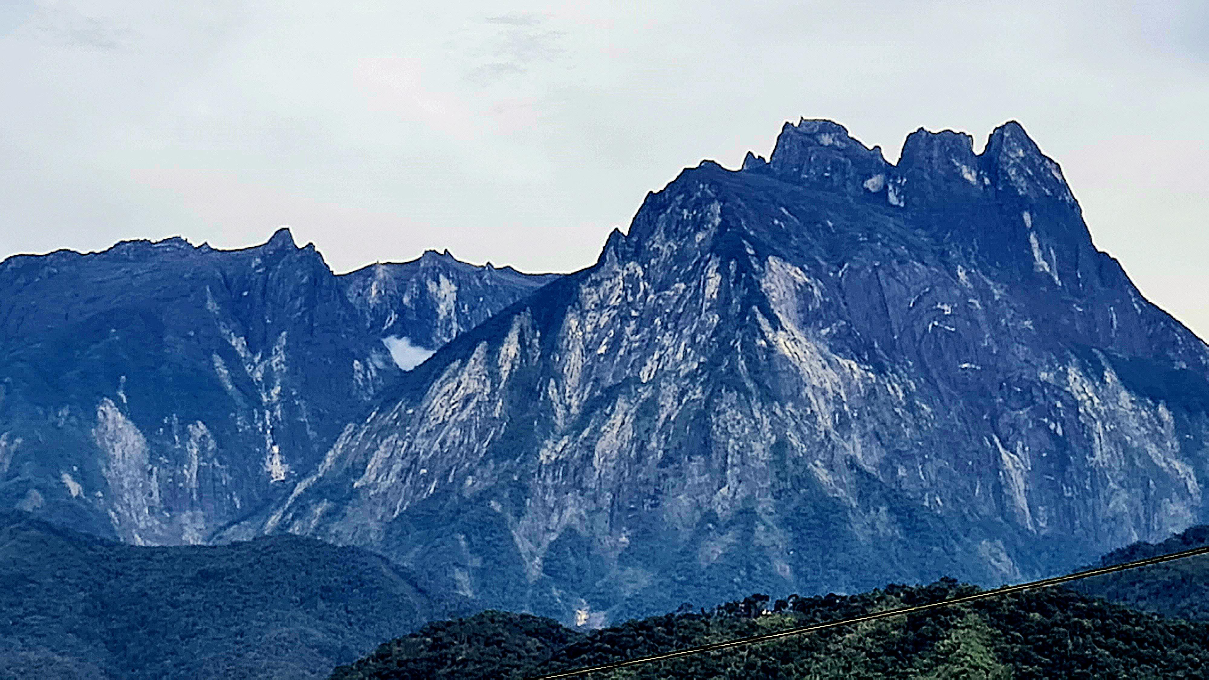The famous Mount Kinabalu. Some cloud formation developing between the ...